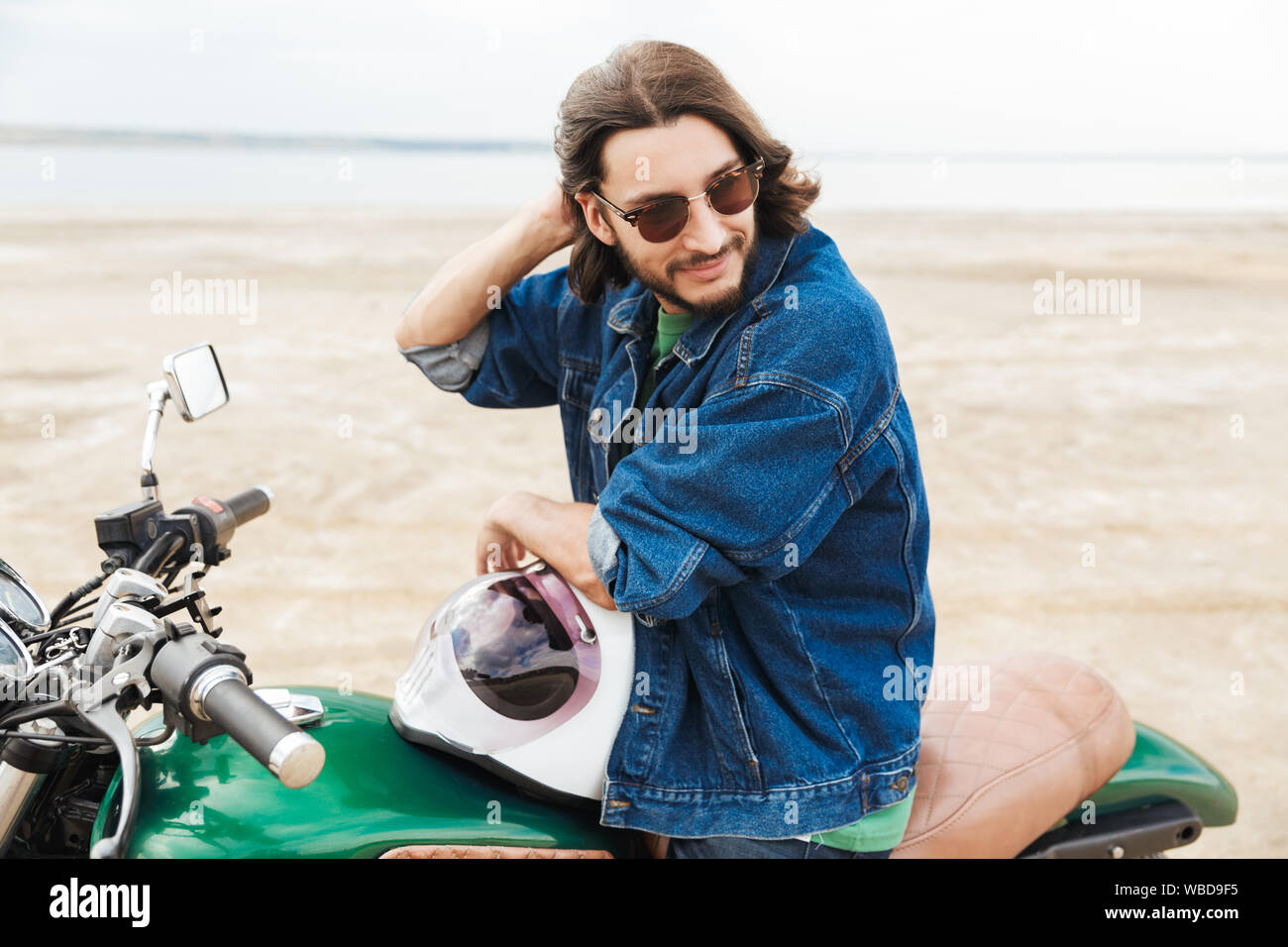 Image of a handsome positive optimistic happy man biker on his bike ...