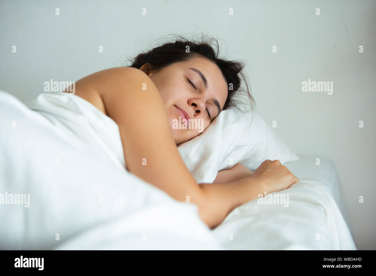 young pretty woman sleeping in bed with white sheets Stock Photo - Alamy