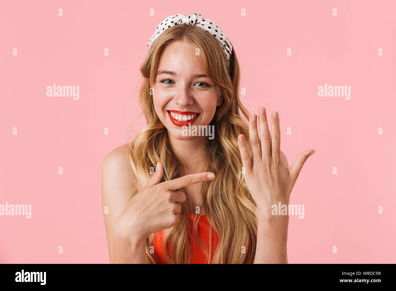 Image Of Gorgeous Young Woman With Long Curly Hair Looking At Camera And Pointing At Her Ring