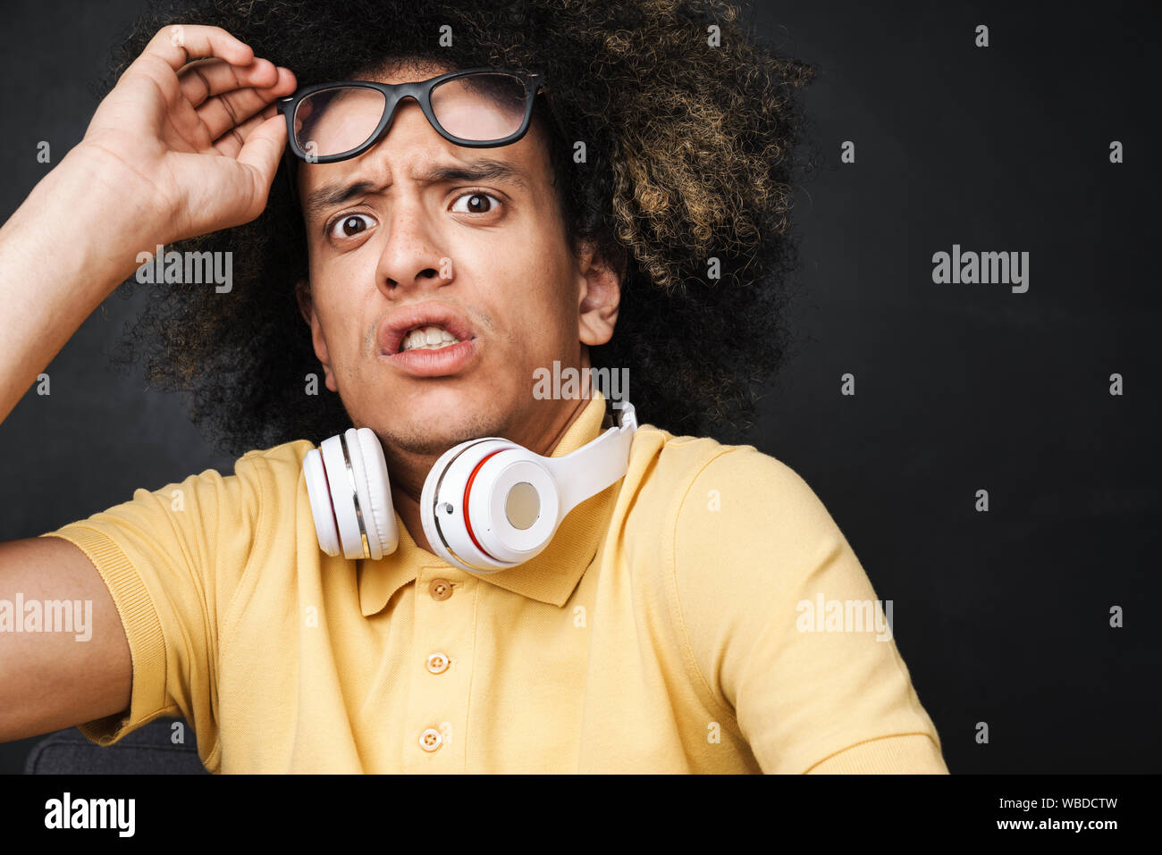 Image Of A Curly Shocked Scared Teenage Guy Posing Over Grey Chalkboard