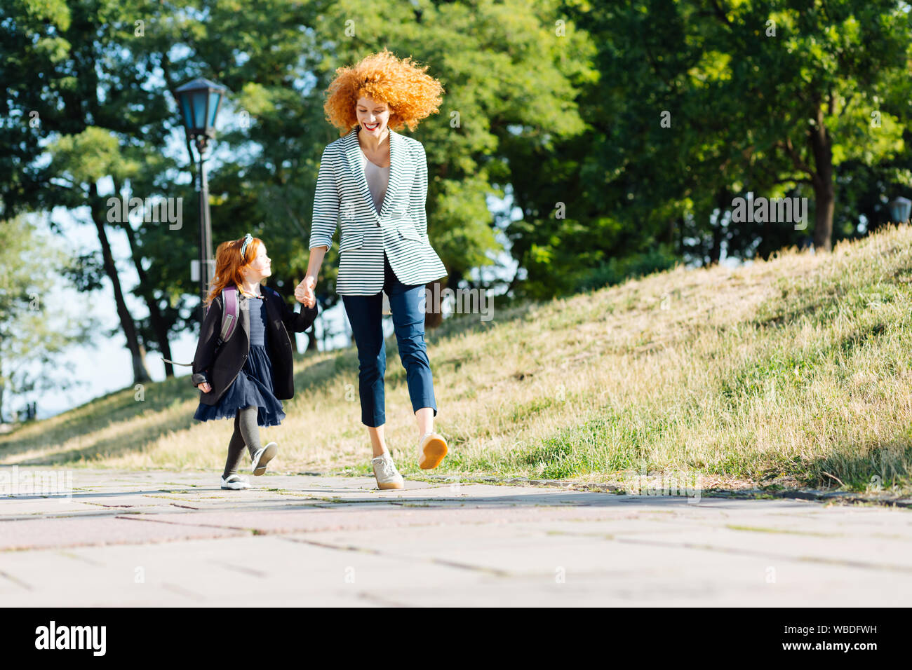 Joyful mom and daughter jumping while walking Stock Photo - Alamy