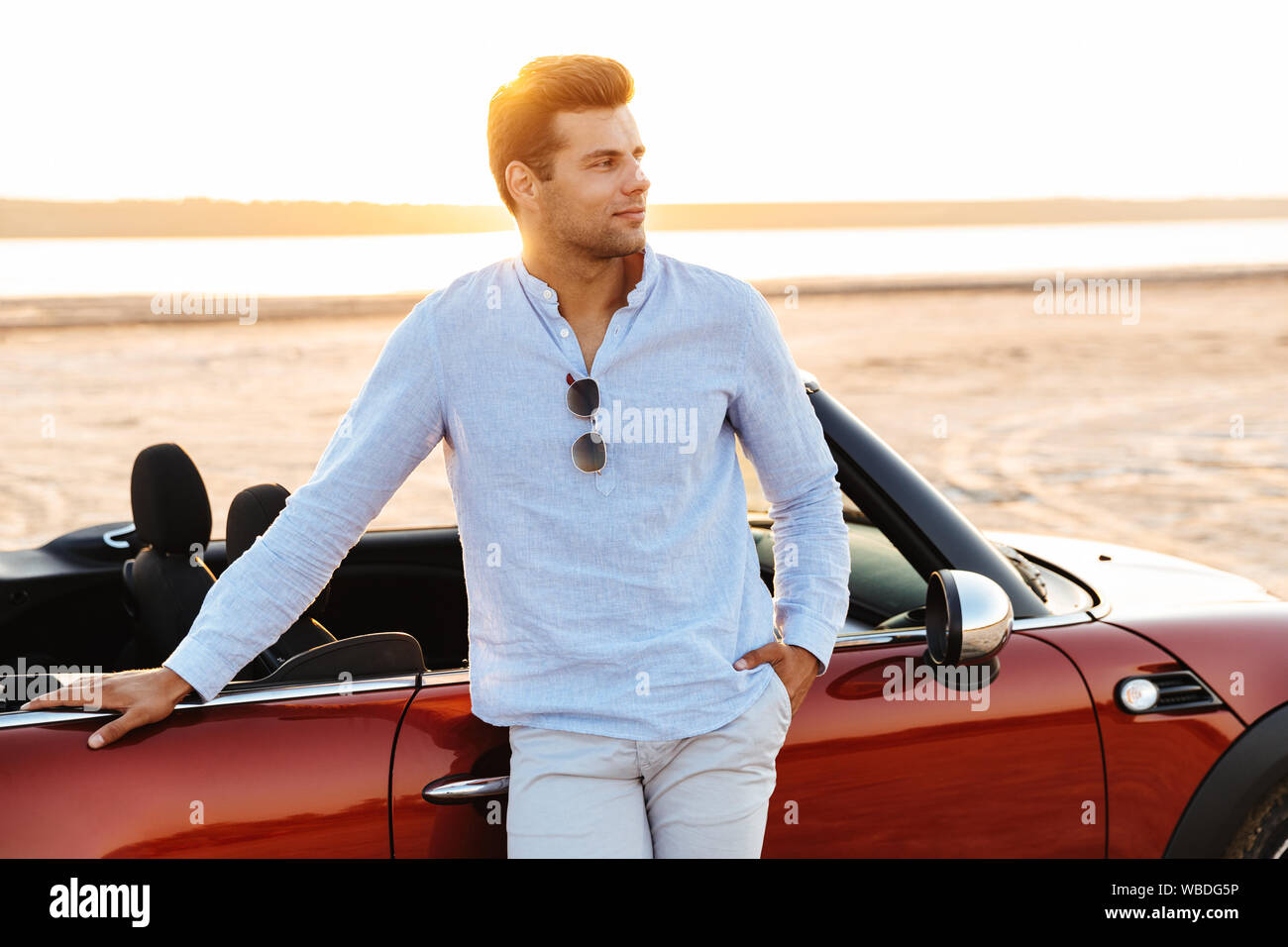 Photo of masculine caucasian man looking aside while standing by ...