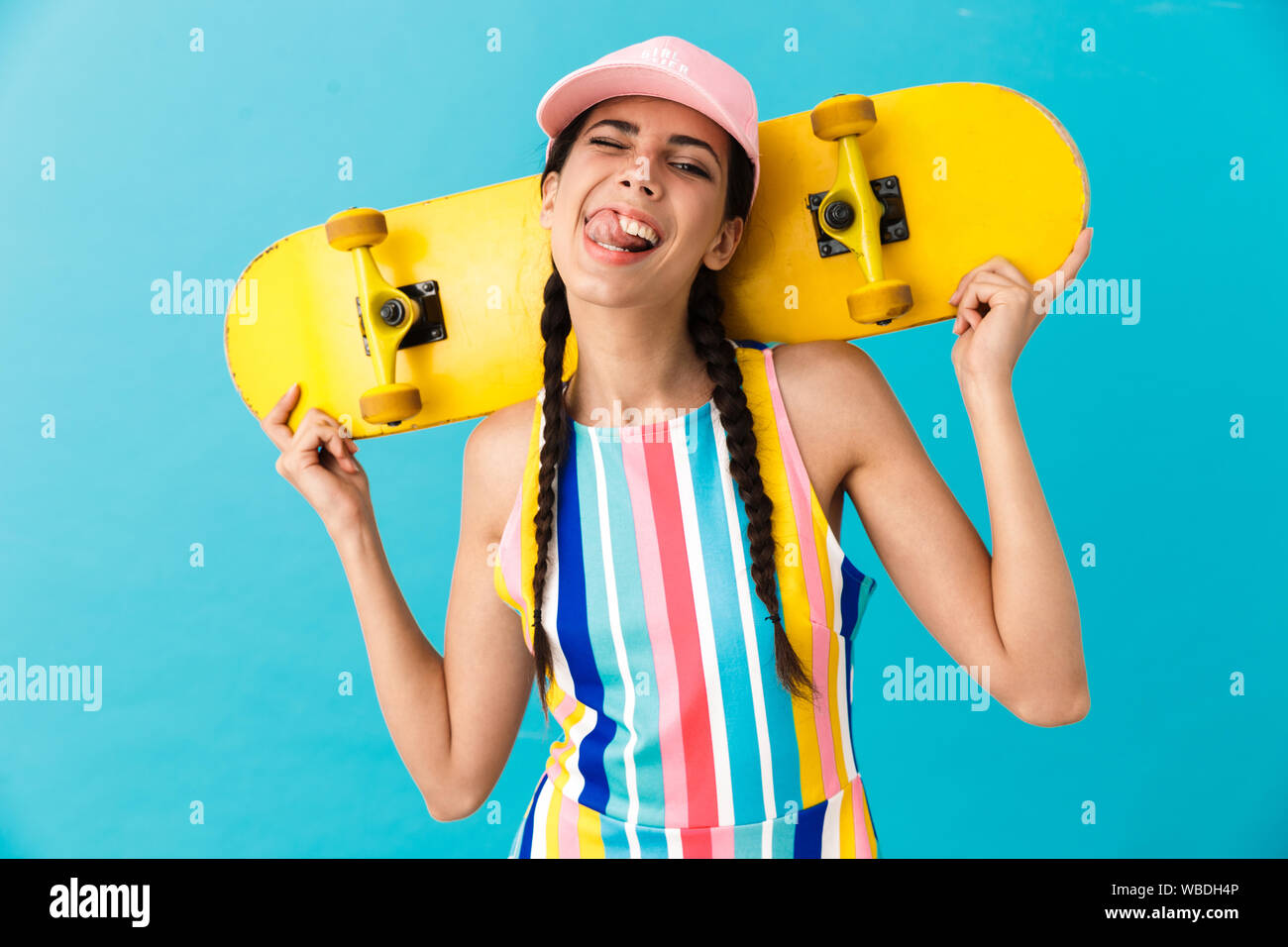 Image of joyful caucasian woman wearing cap winking while carrying ...