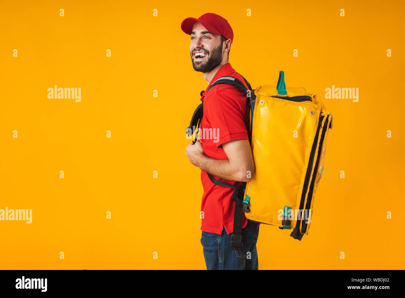 Photo of young delivery man in red uniform carrying backpack with ...