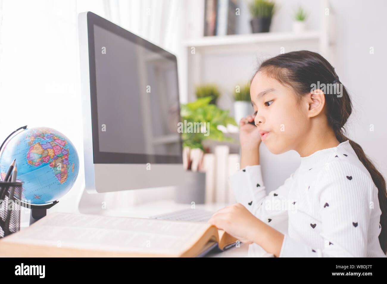 happy beautiful little girl student using mobile pad computer studying ...