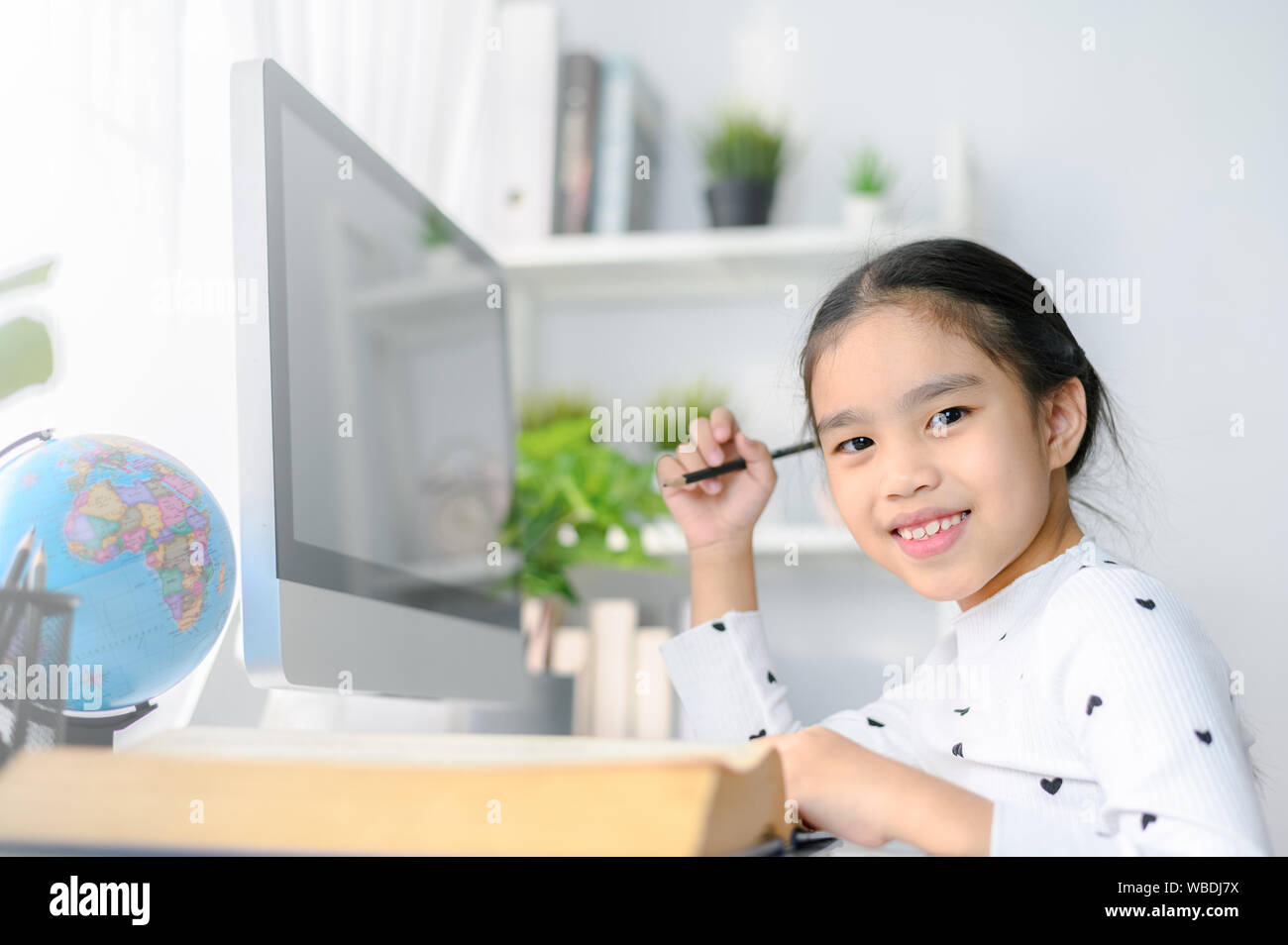 happy beautiful little girl student using mobile pad computer studying ...