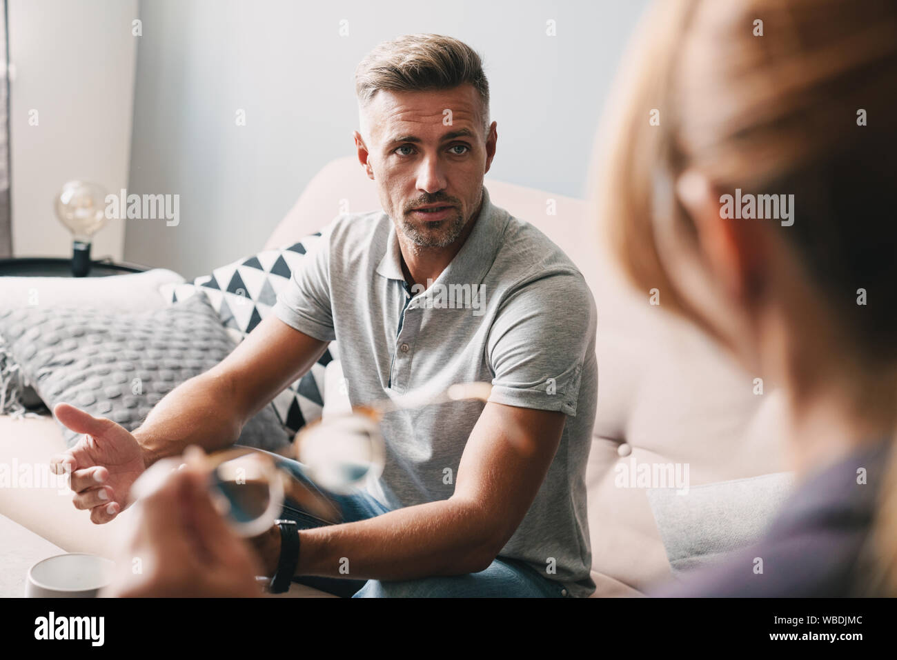 Photo of brooding handsome man having conversation with psychologist on ...