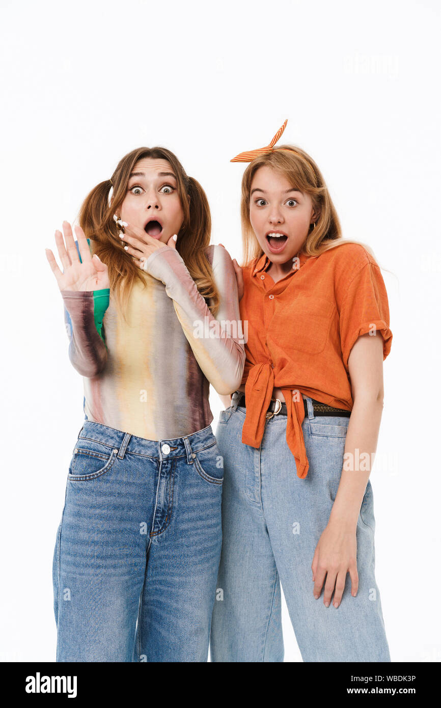 Portrait of two shocked girls wearing casual clothes screaming and ...