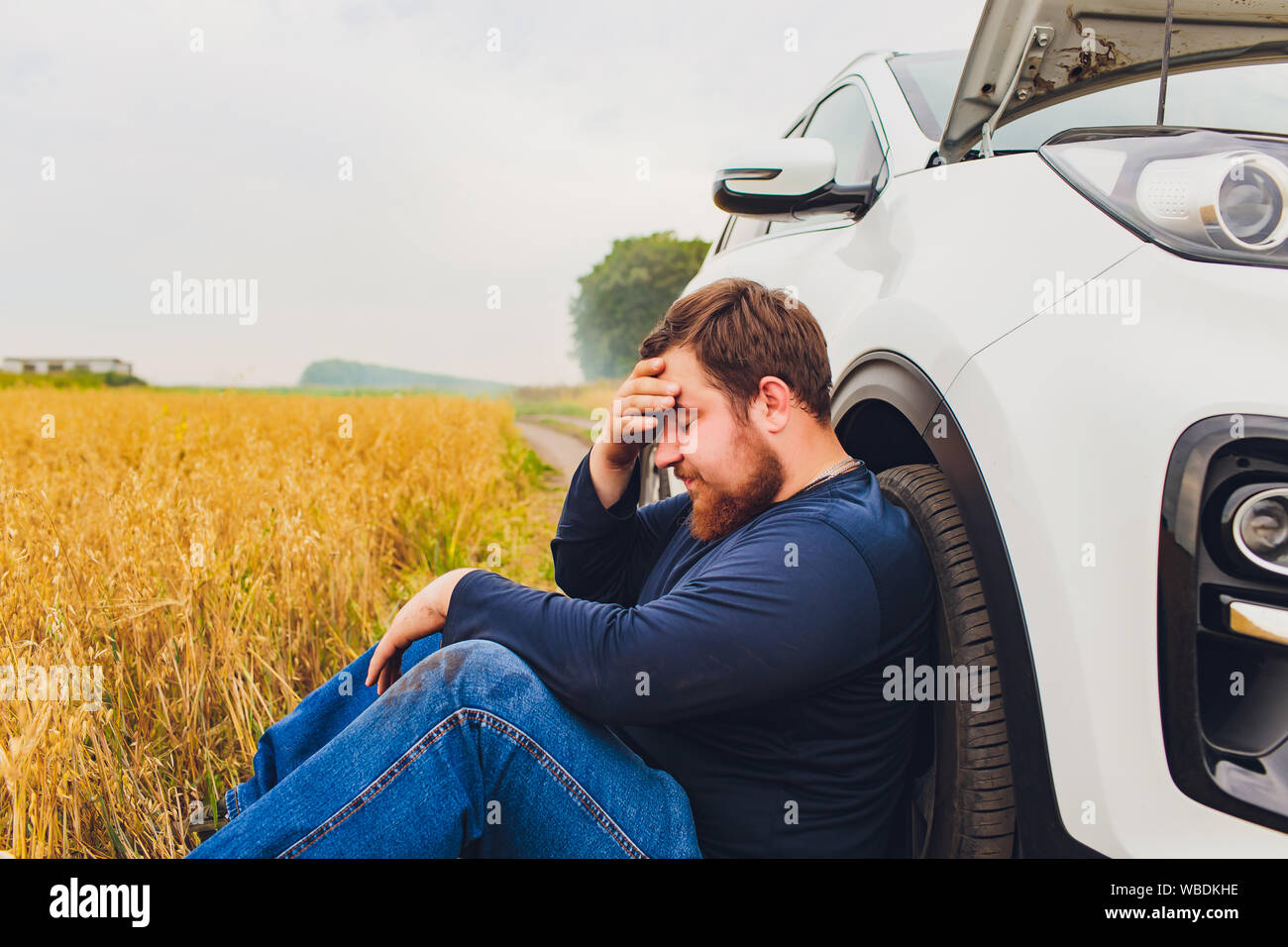 Stressed and frustrated driver pulling his hair while standing on the ...