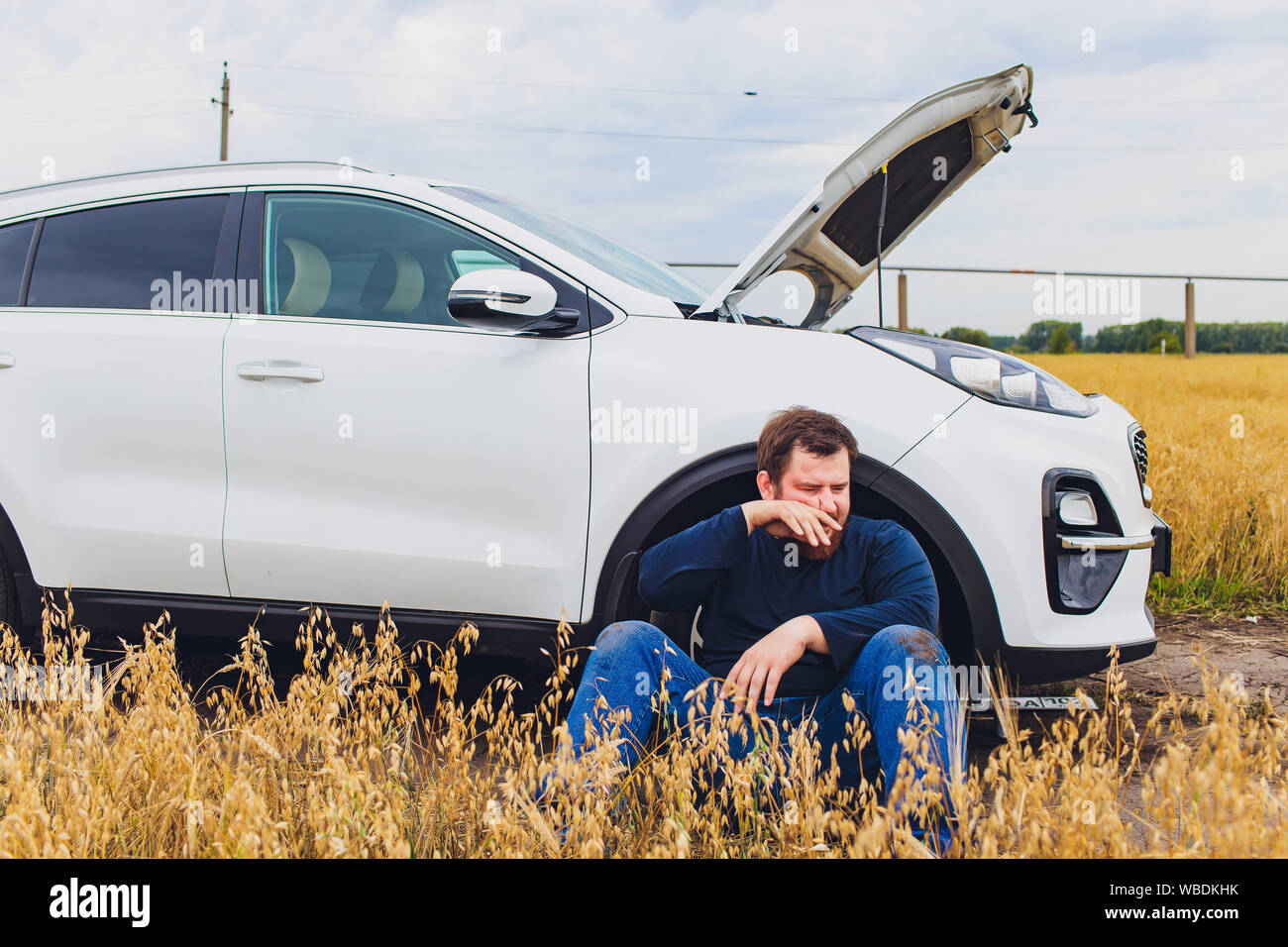 Stressed and frustrated driver pulling his hair while standing on the ...