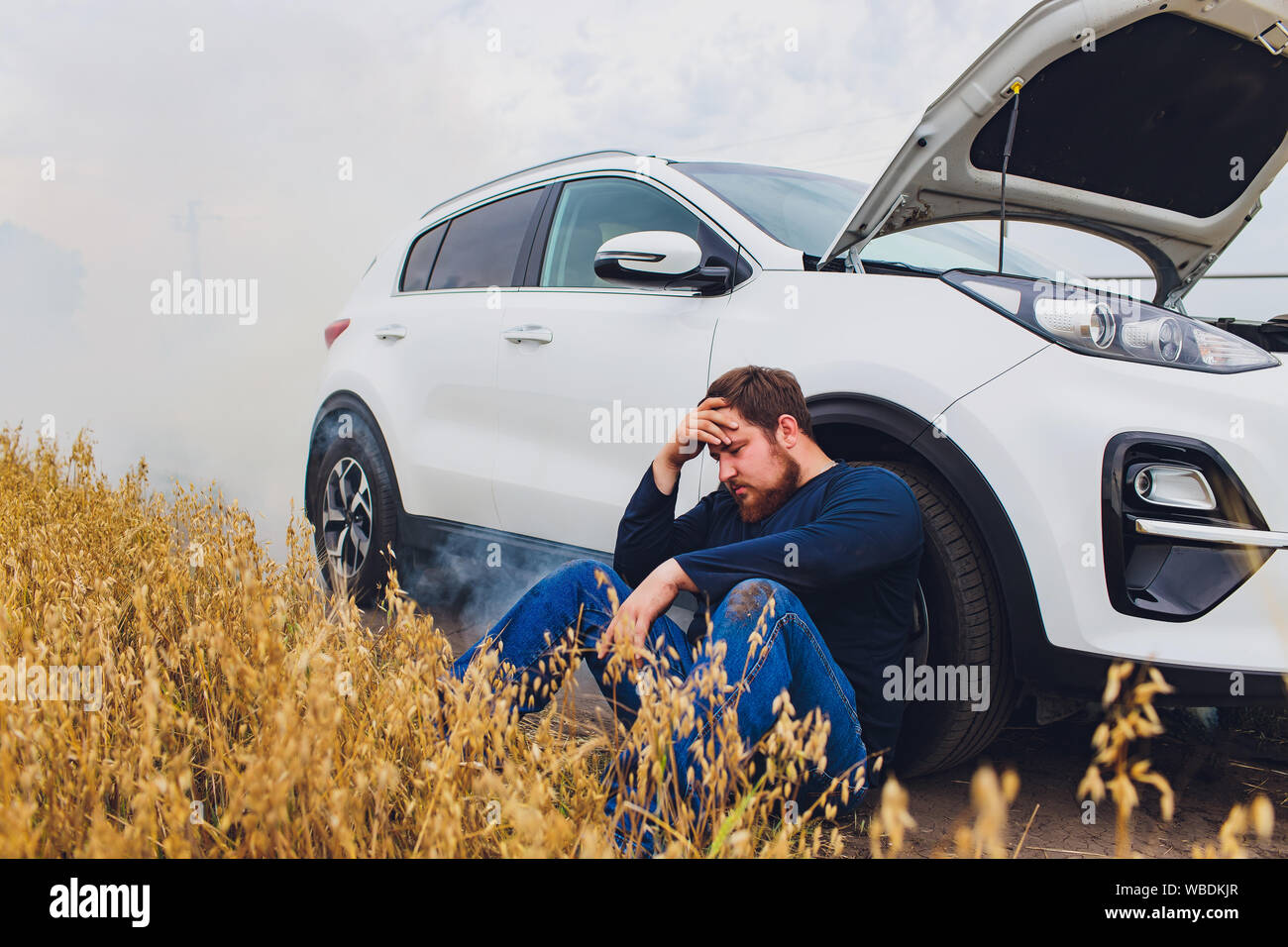 Stressed and frustrated driver pulling his hair while standing on the ...