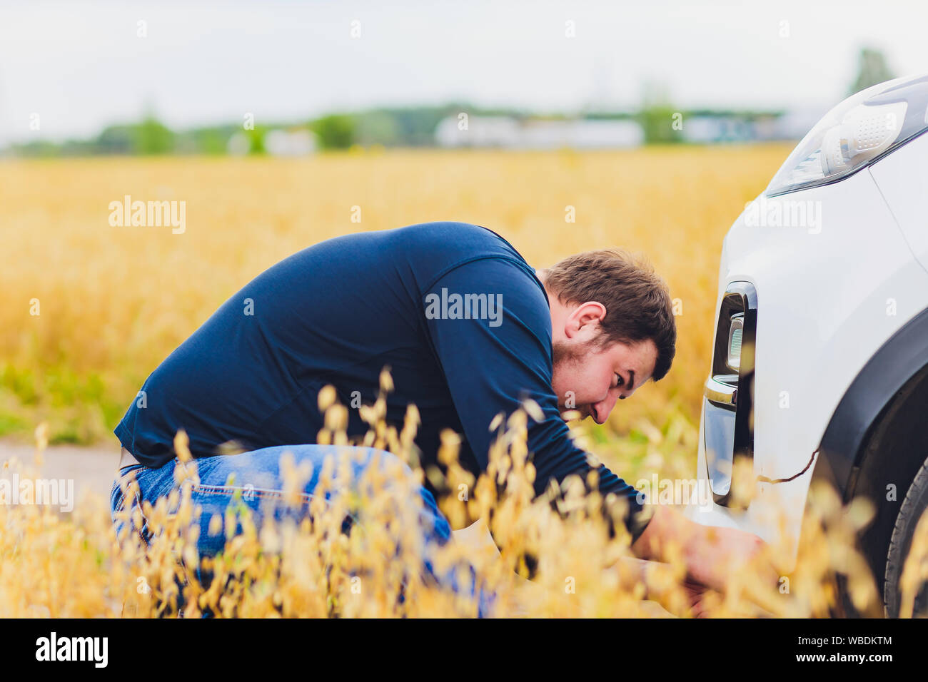 Stressed and frustrated driver pulling his hair while standing on the ...