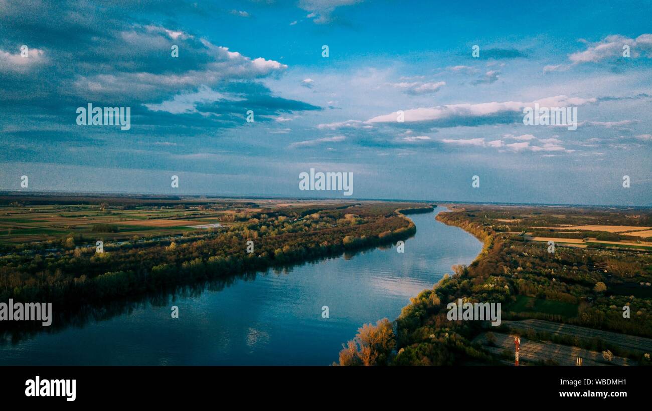 Vertical shot of a beautiful river in a countryside field with ...