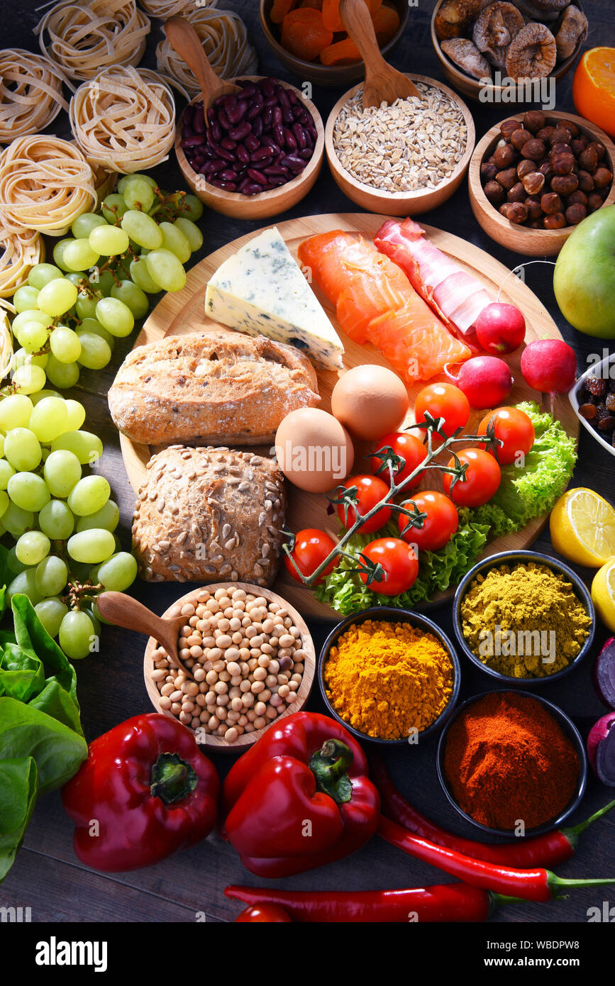 Composition with assorted organic food products on wooden kitchen table ...
