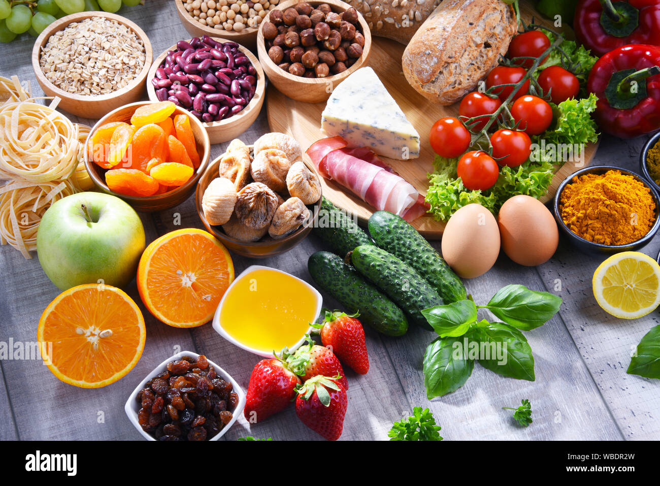 Composition with assorted organic food products on wooden kitchen table ...
