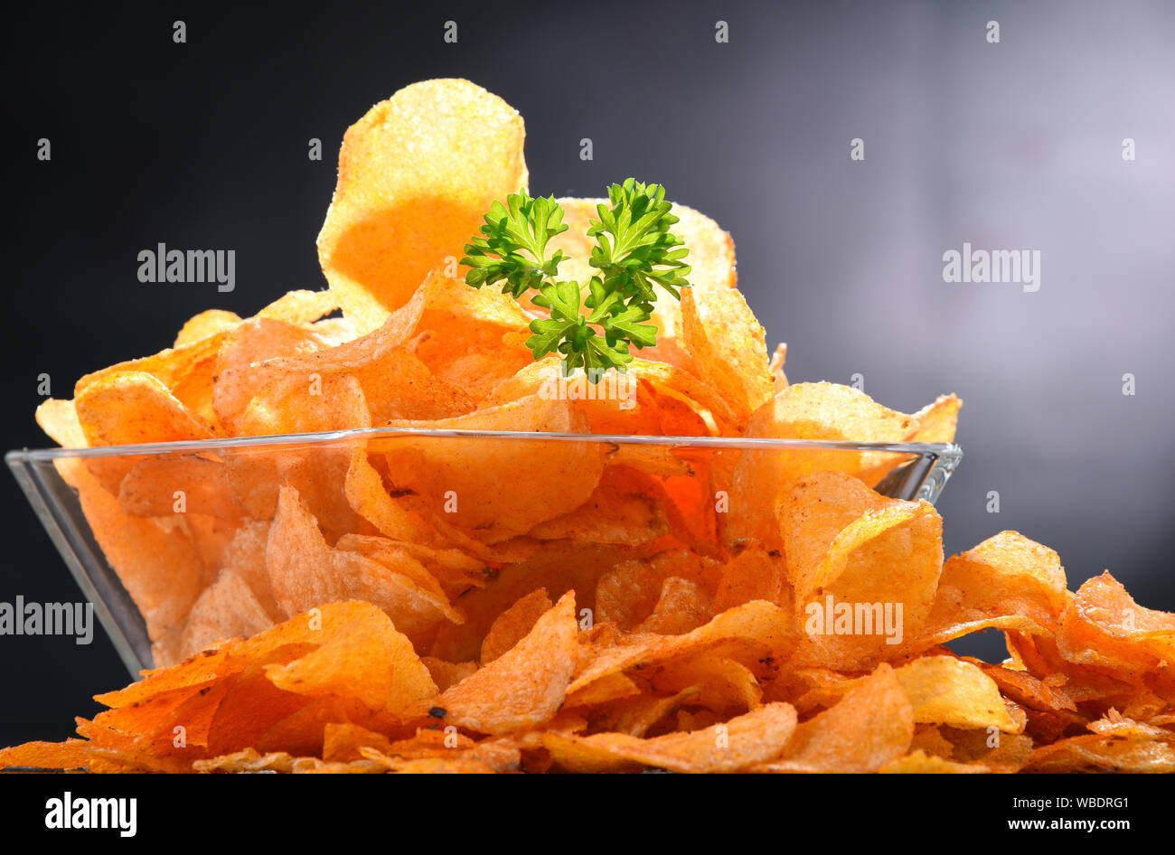 Composition with glass bowl of potato chips Stock Photo - Alamy