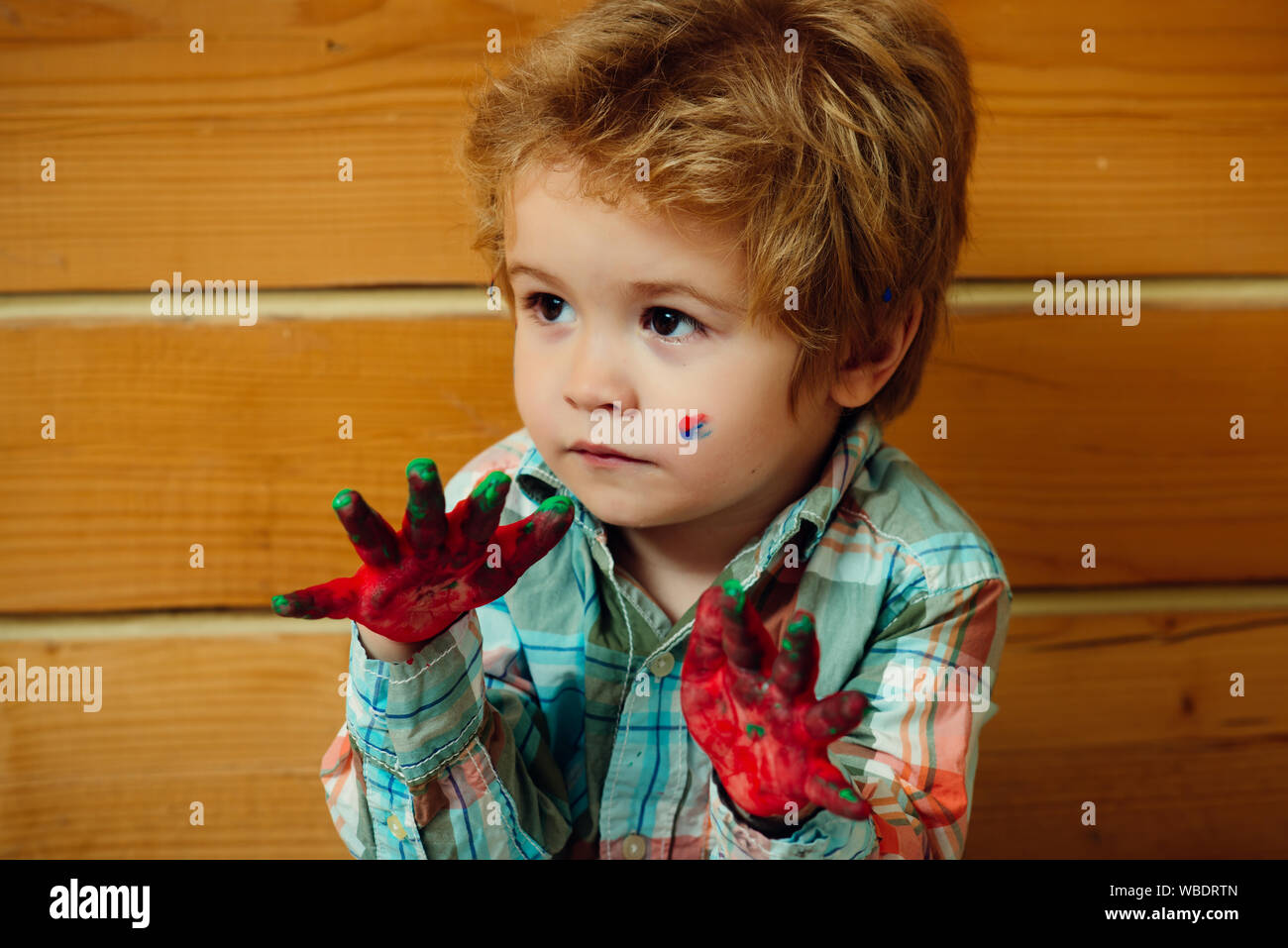 Boy artist sitting on wooden wall Stock Photo - Alamy