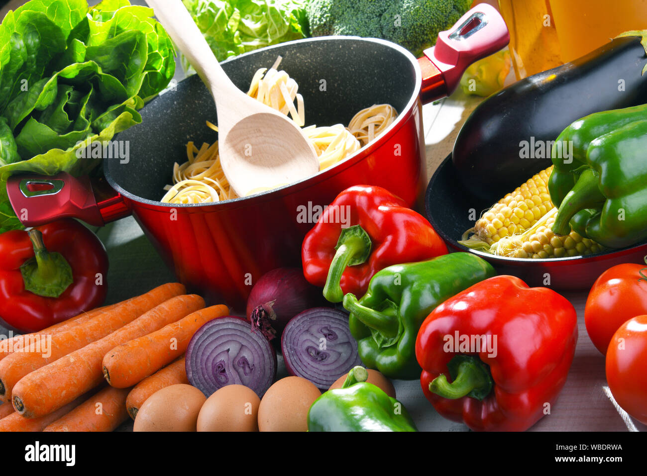 Fresh vegetables and cooking pot on kitchen table Stock Photo - Alamy