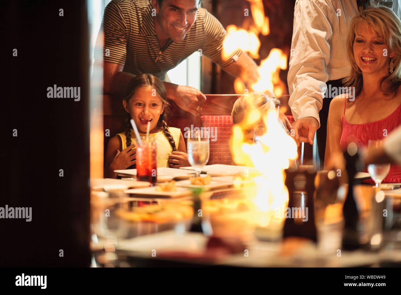 Family at a Japanese teppanyaki restaurant, watching the chef fire the ...