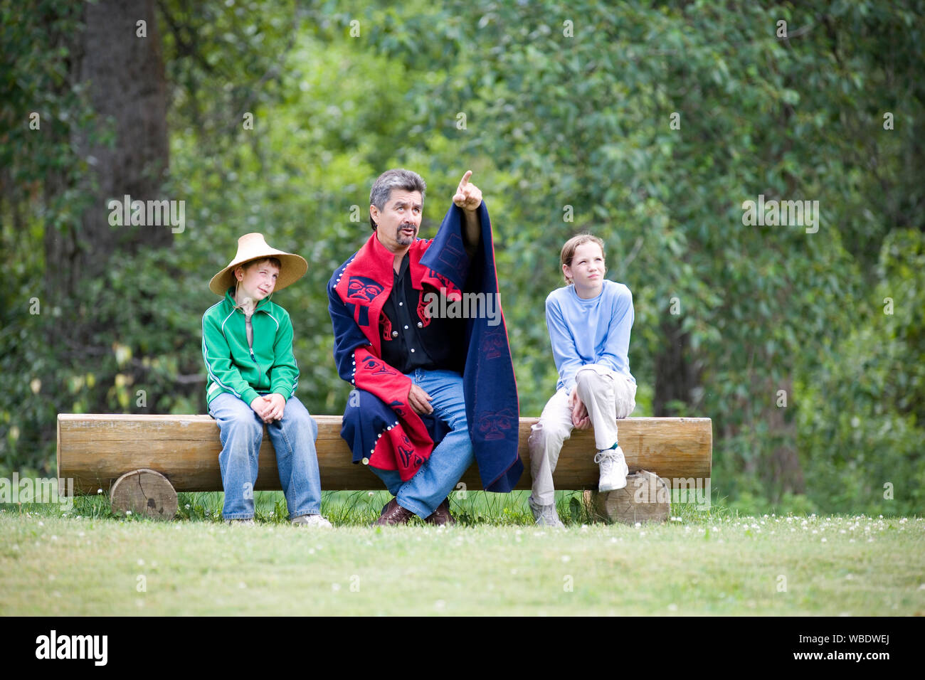 Native American man explaining something to two children Stock Photo ...