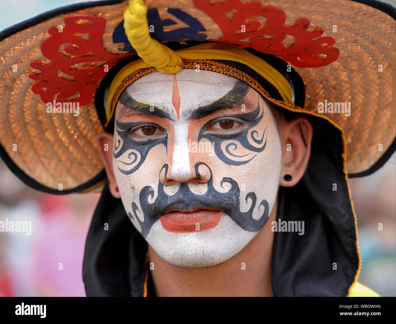 Costumed parade participant with traditional painted face at Bangkok’s ...