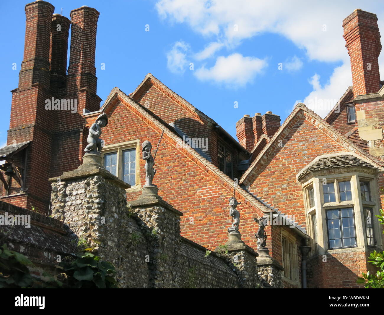 View of the multiple rooflines, Tudor chimneys and cherub statues ...
