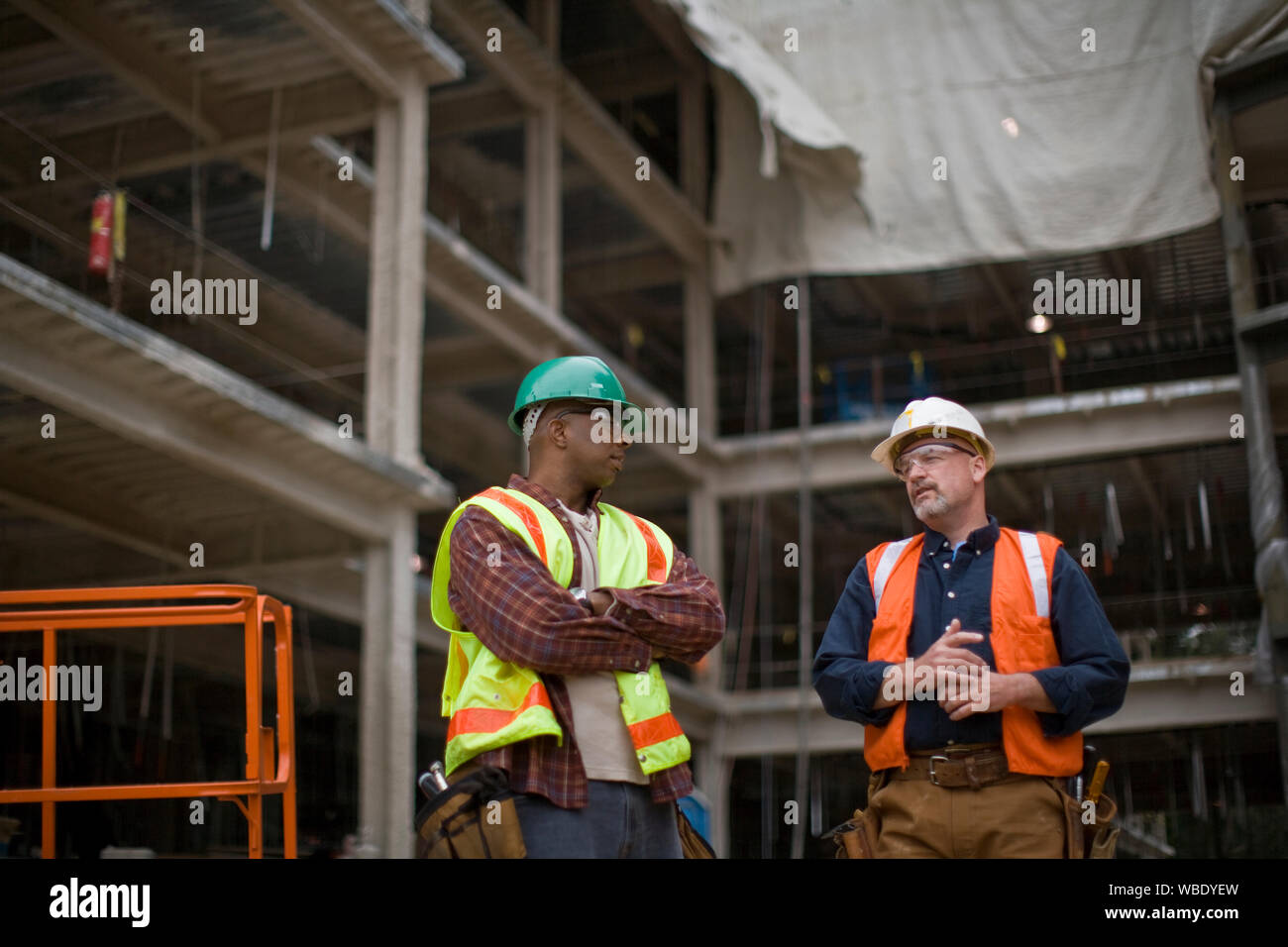 Two builders talking on a construction site Stock Photo - Alamy