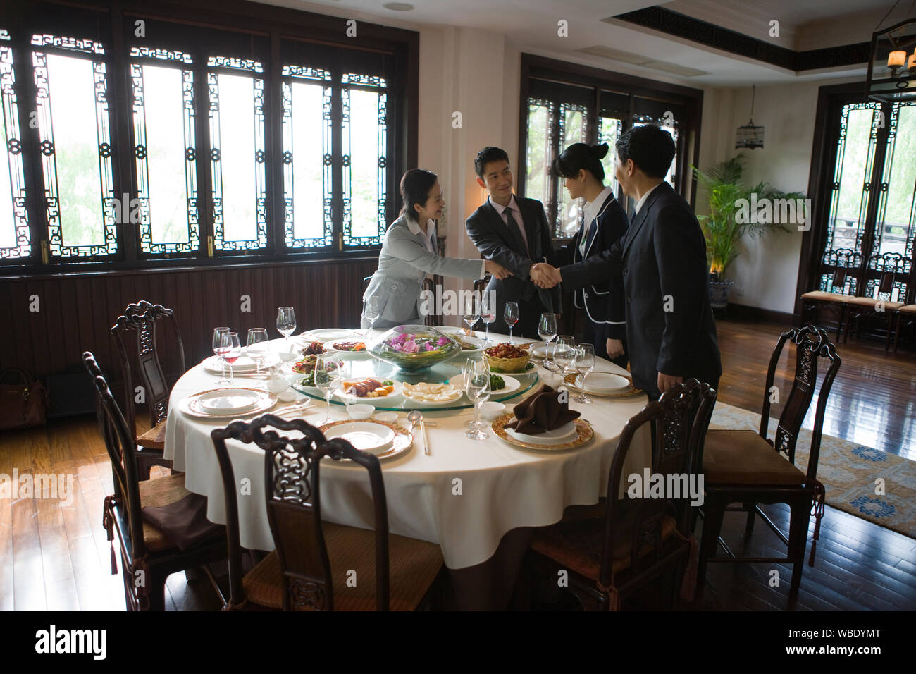 Business colleagues shaking hands inside a restaurant Stock Photo - Alamy