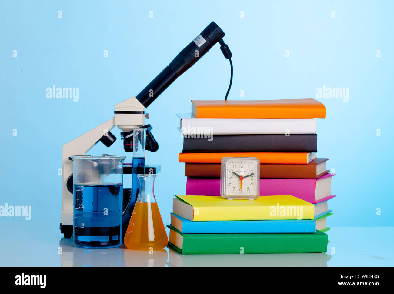 Books and a microscope on the desk of the student Stock Photo - Alamy