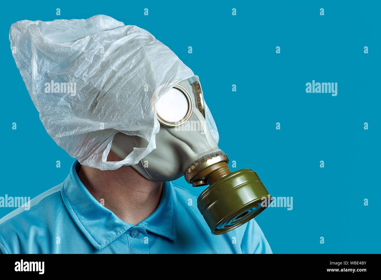 a man in a gas mask and a plastic bag on his head symbolizes the ...