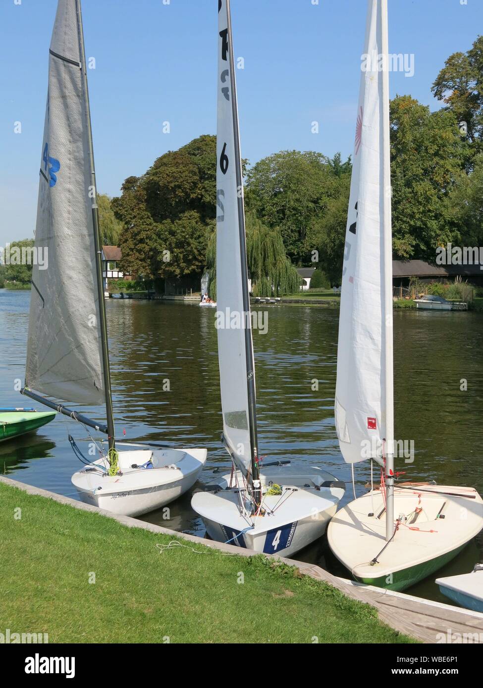 A trio of small sailing boats are moored on a perfect summer's day on ...