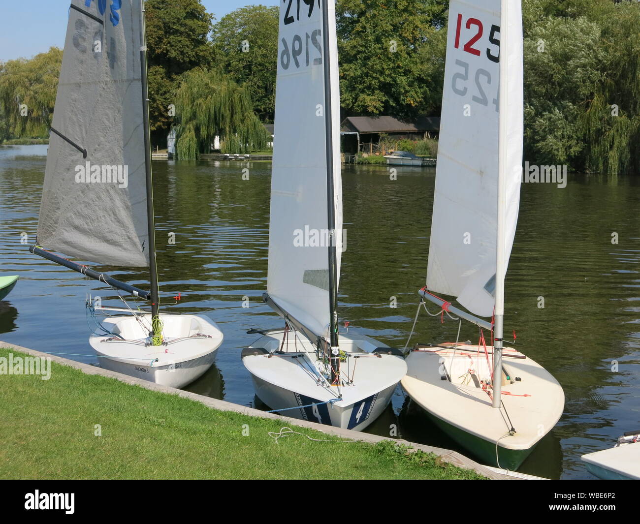 A trio of small sailing boats are moored on a perfect summer's day on ...