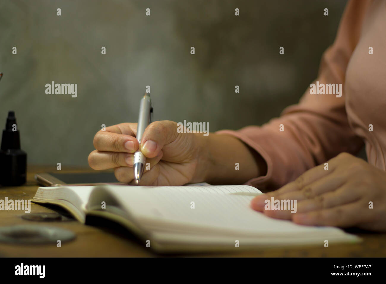 Young business woman working with a pen at office, she staying overtime ...