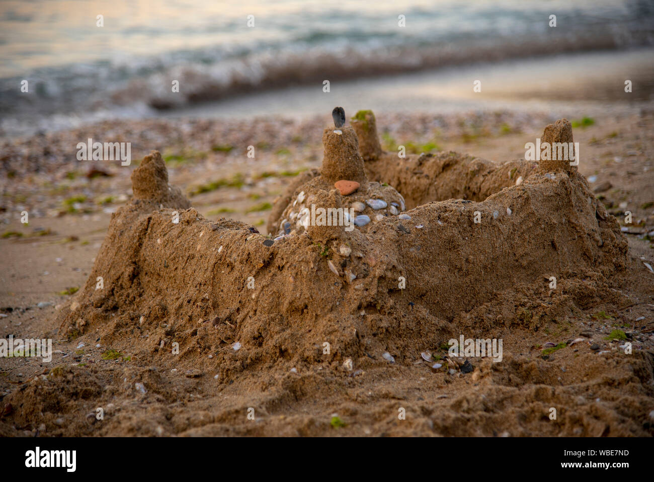 Sand castle, decorated with shells, on the beach. Photographed at dawn ...