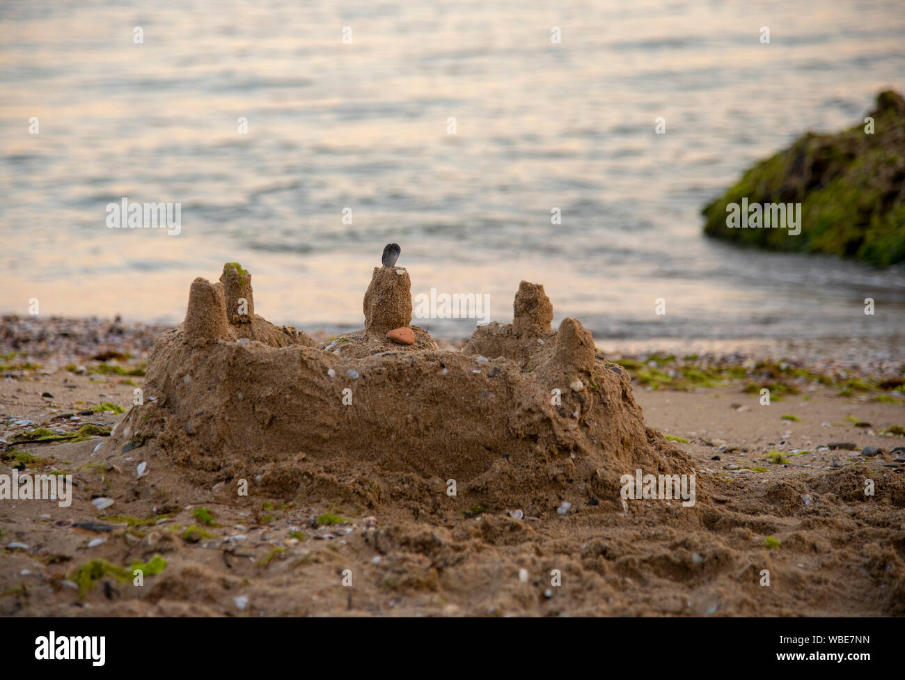Sand castle, decorated with shells, on the beach. Photographed at dawn ...