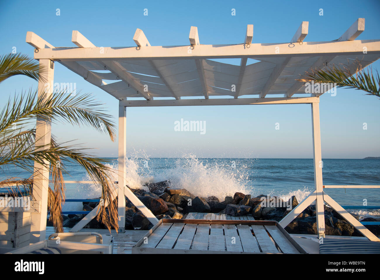 White wooden veranda on the beach.In the background, the waves break on ...
