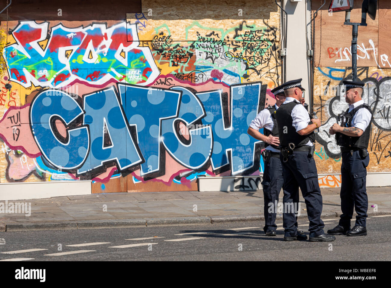 Police officers gathered by graffiti with the word Catch, at the ...