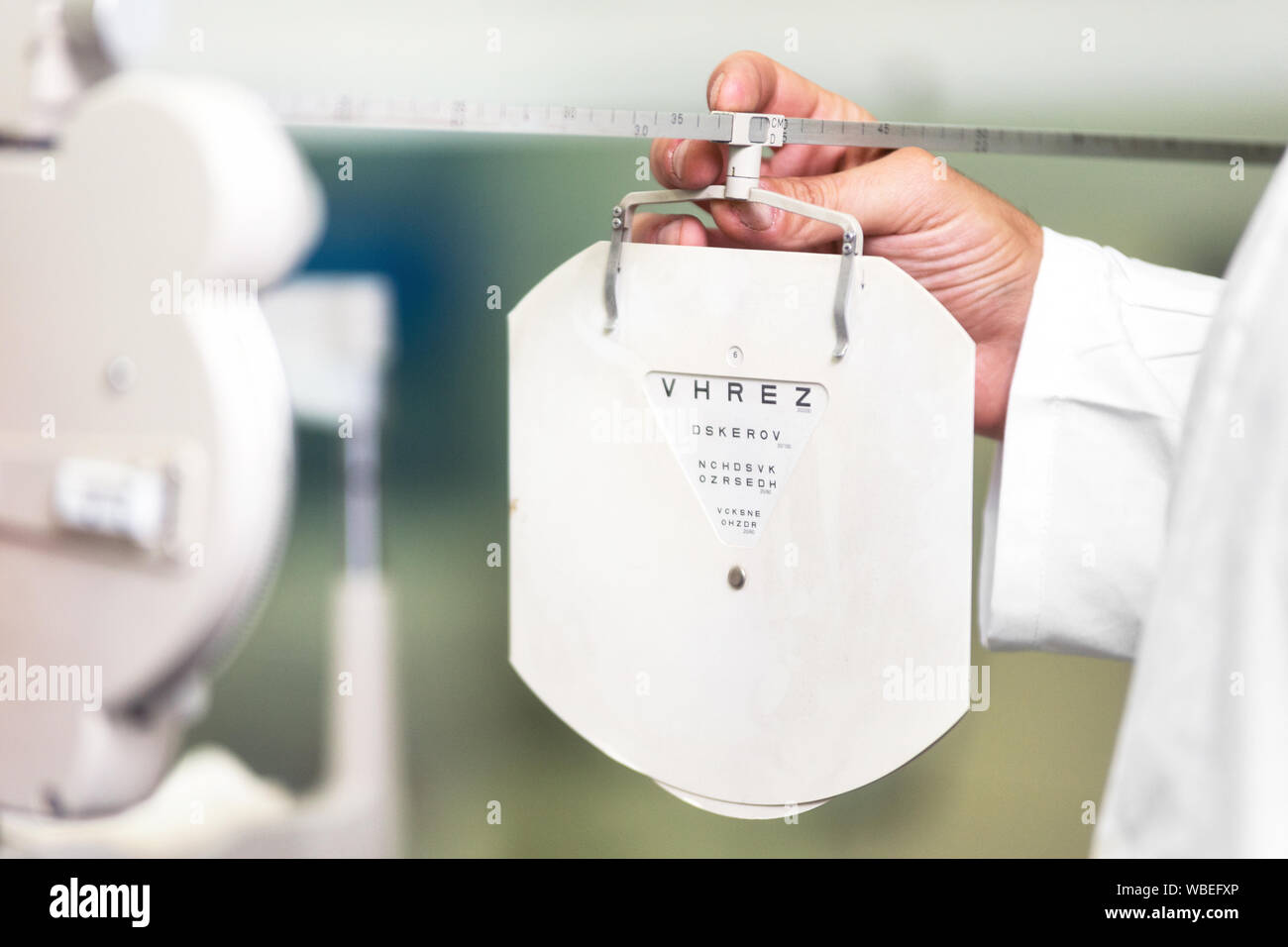 Patient is reading the optometrist chart in modern ophthalmology clinic ...