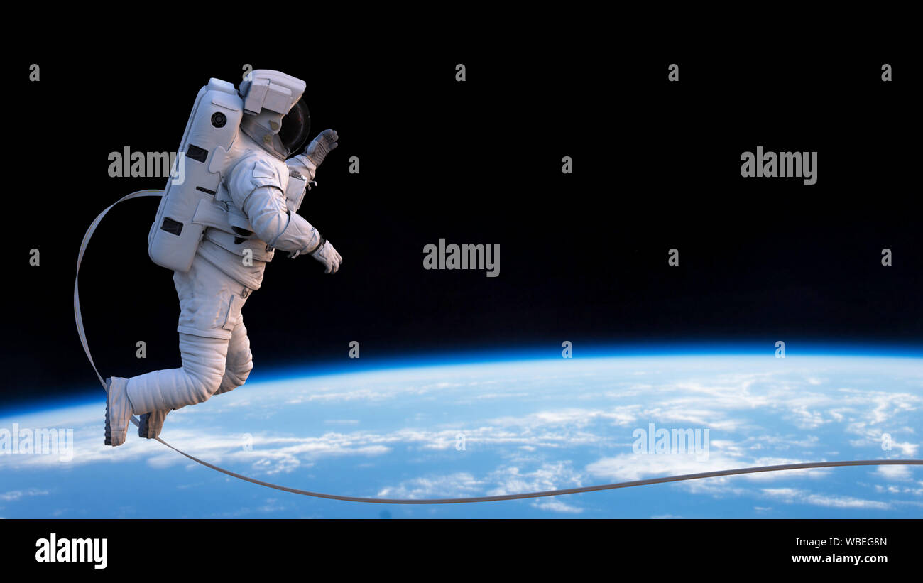 astronaut with safety tether performing a spacewalk in empty space ...