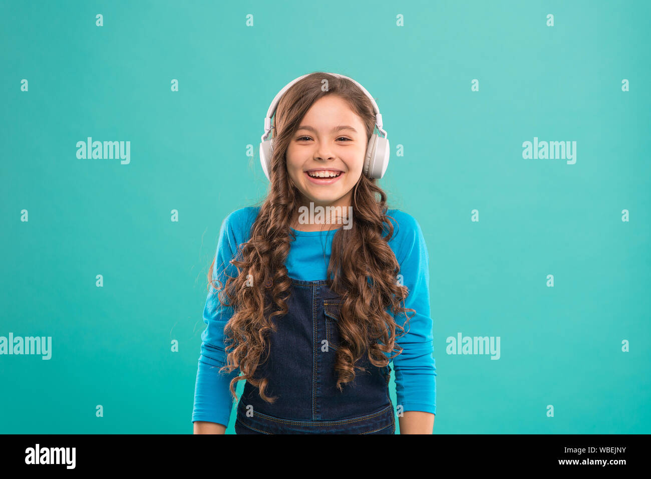 Play the moment. Cute kid listening to music in stereo headset ...