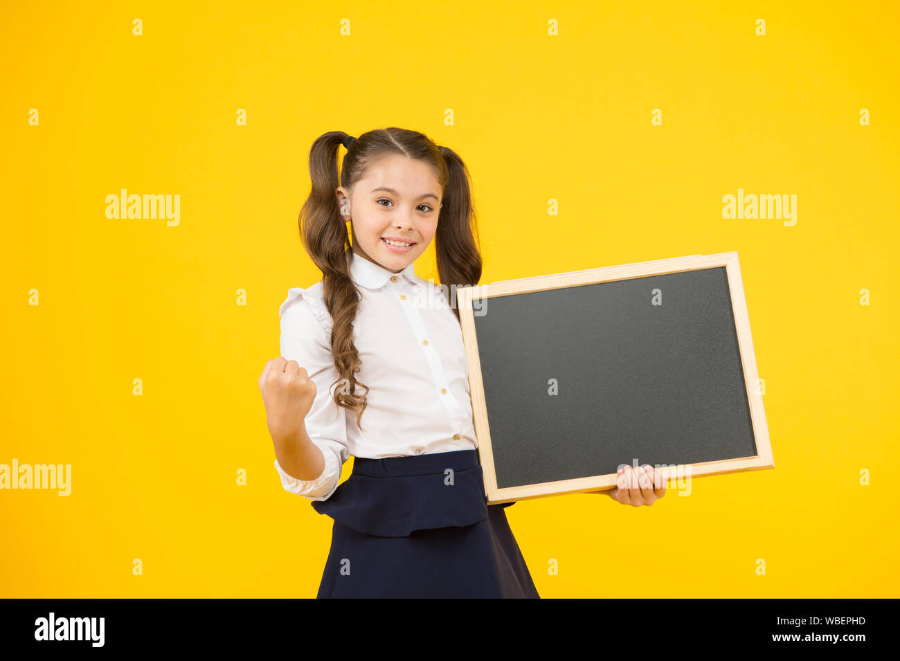 Writing to the memory. Little girl holding black writing surface on ...