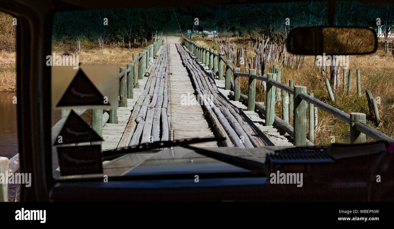Car approaches a crude wooden bridge to cross a river in Botswana Stock ...