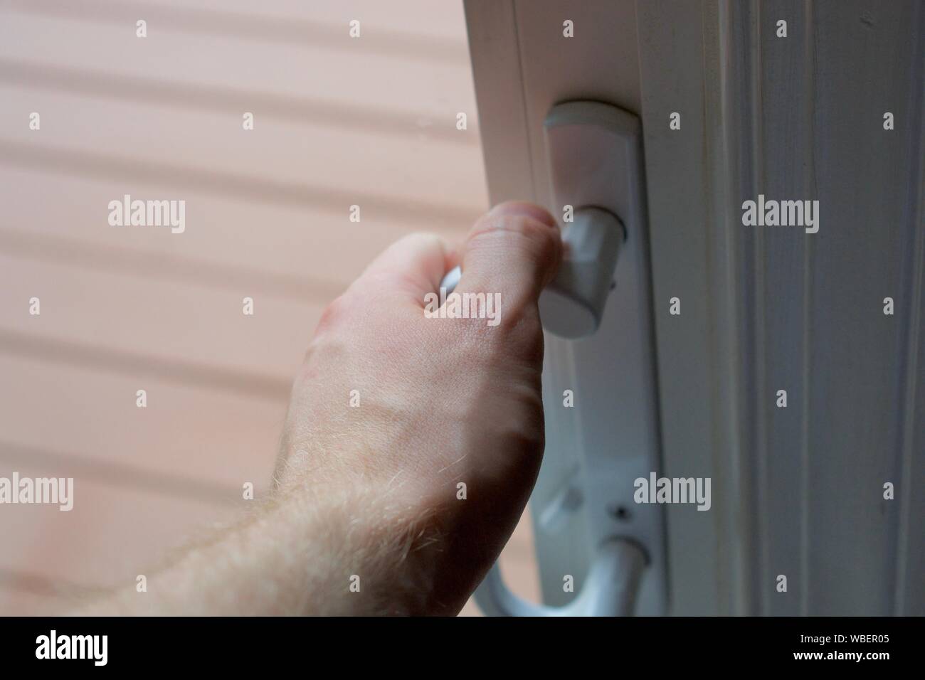 Hand pulling on door handle to go outside. Deck visible through window ...
