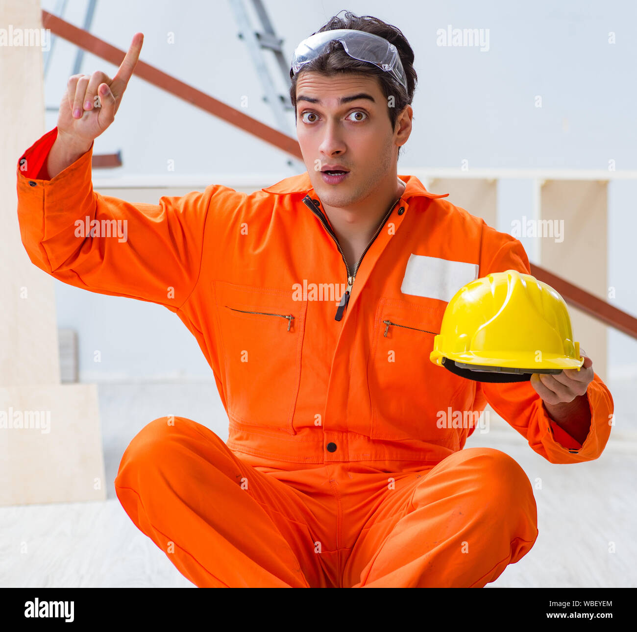 The carpenter wearing yellow hardhat in contractor workshop Stock Photo ...