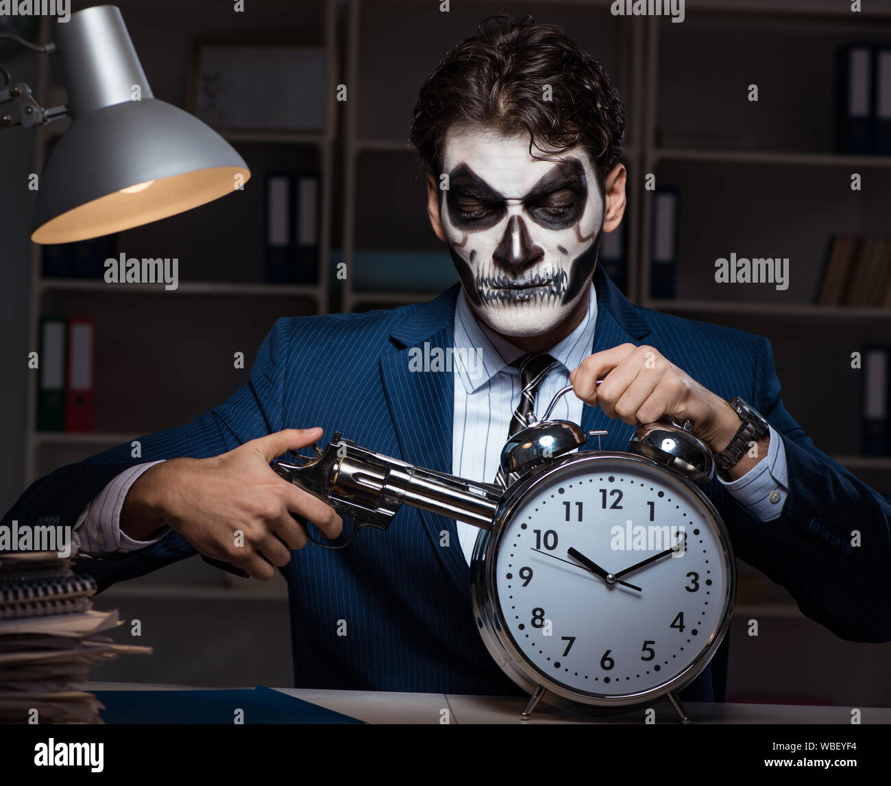 The businessman with scary face mask working late in office Stock Photo ...