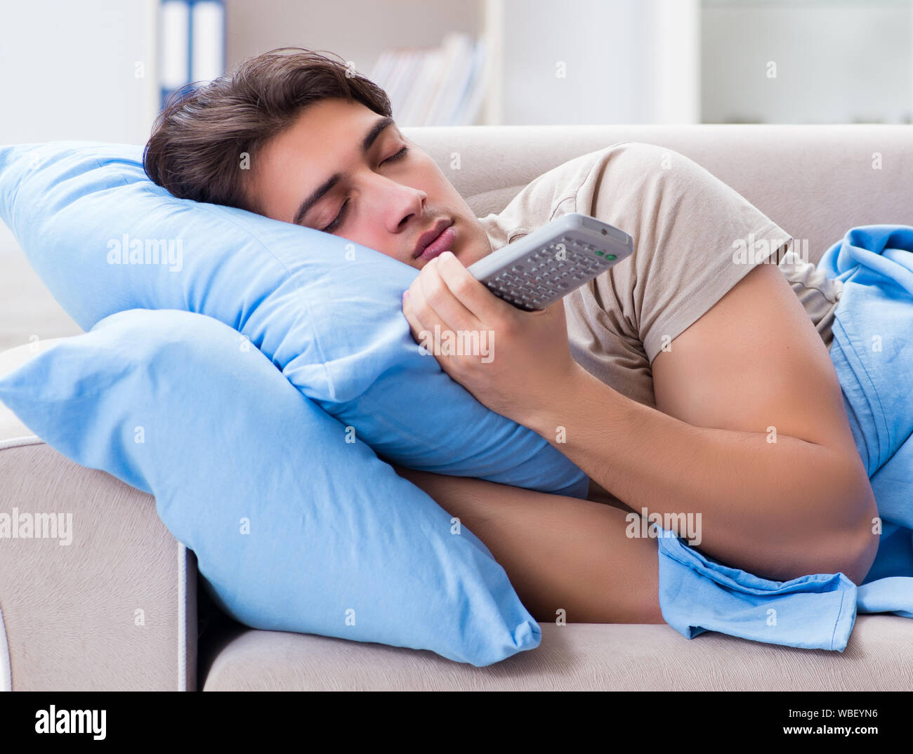 The man watching tv from bed holding remote control unit Stock Photo ...