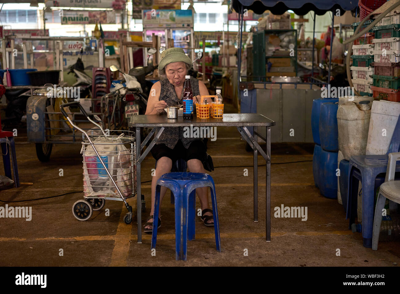 Woman eating alone outside at a Thailand food market, Southeast Asia ...