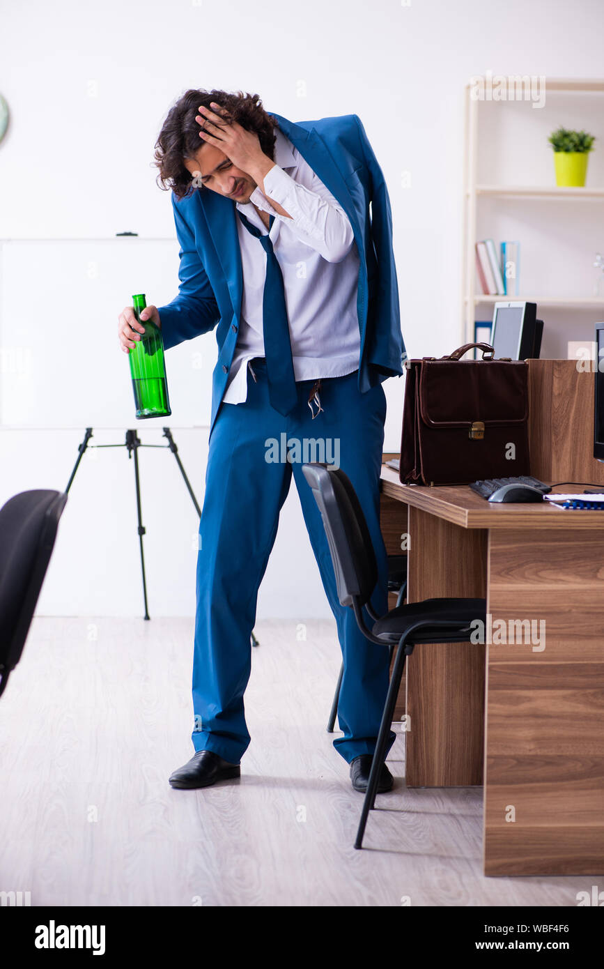 The young drunk employee in the office Stock Photo - Alamy