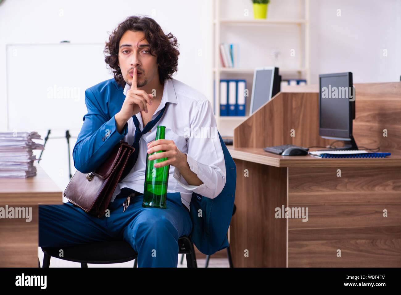 The young drunk employee in the office Stock Photo - Alamy