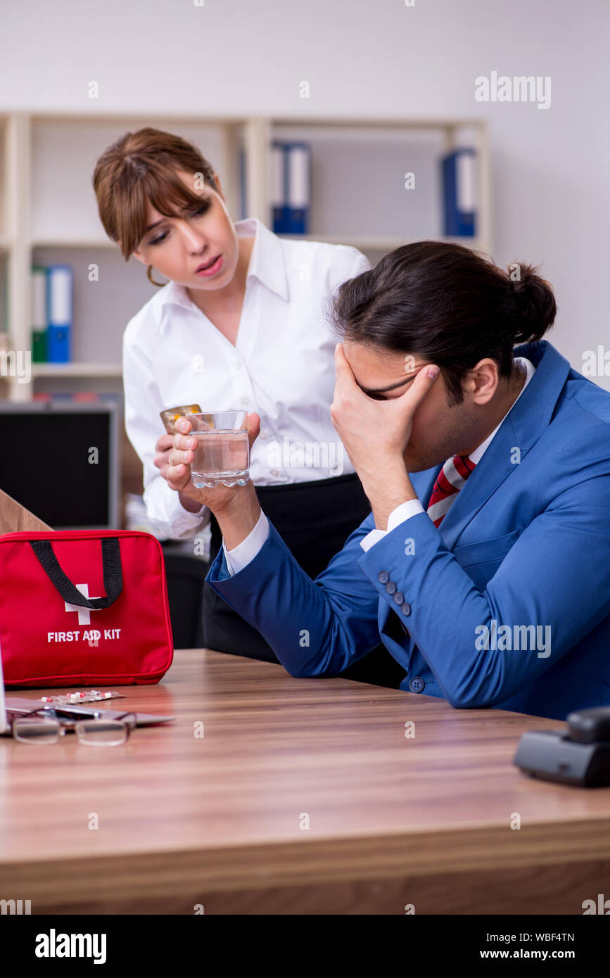 Employee receiving first aid in office Stock Photo - Alamy